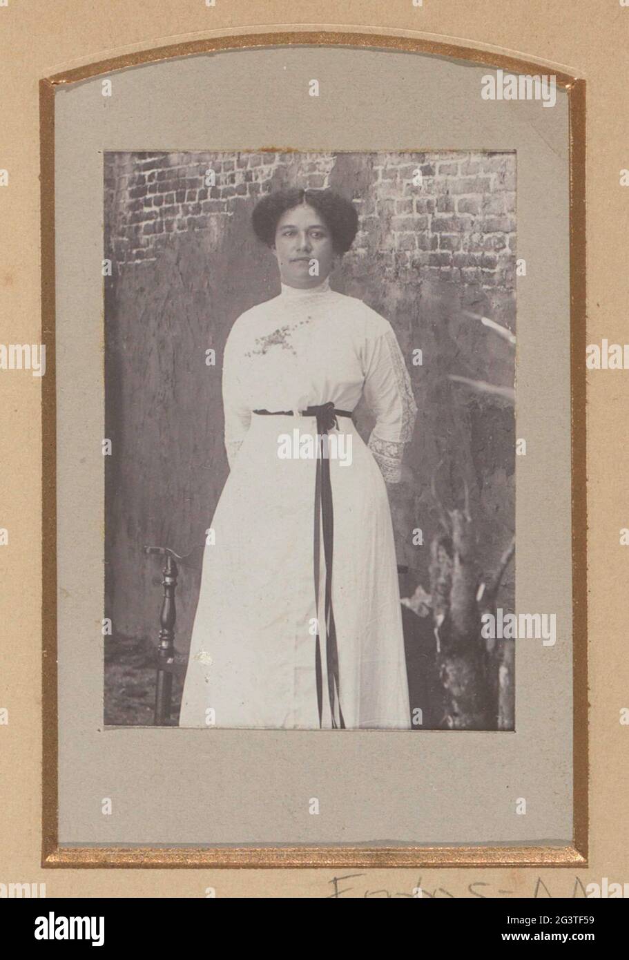 Portrait of (presumably) a Surinamese woman in a long dress standing in ...