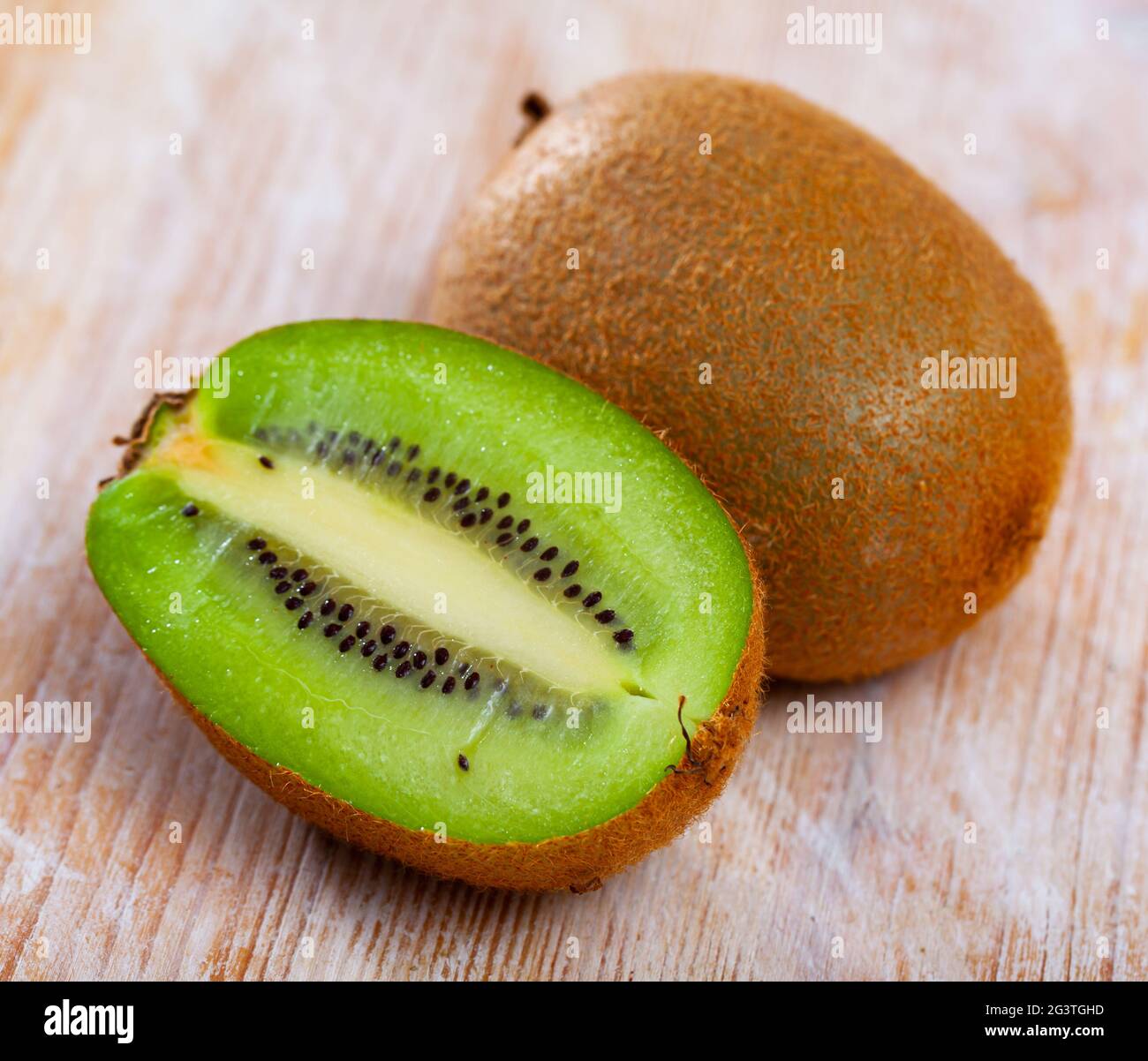 Ripe kiwi on wooden table Stock Photo - Alamy