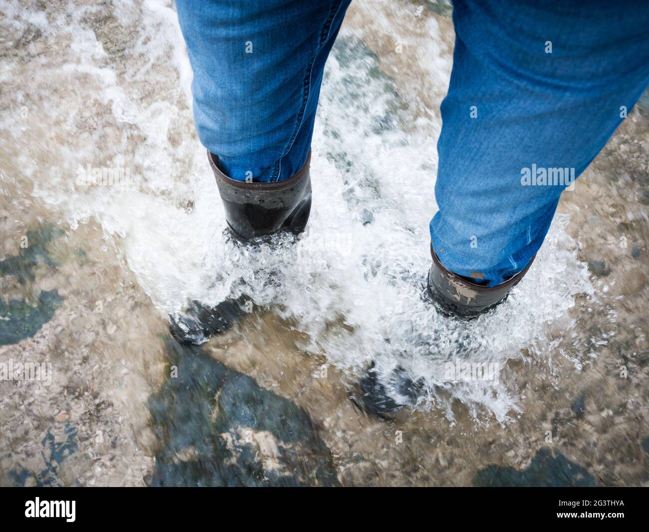 Walking in a river with rubber boots Stock Photo - Alamy