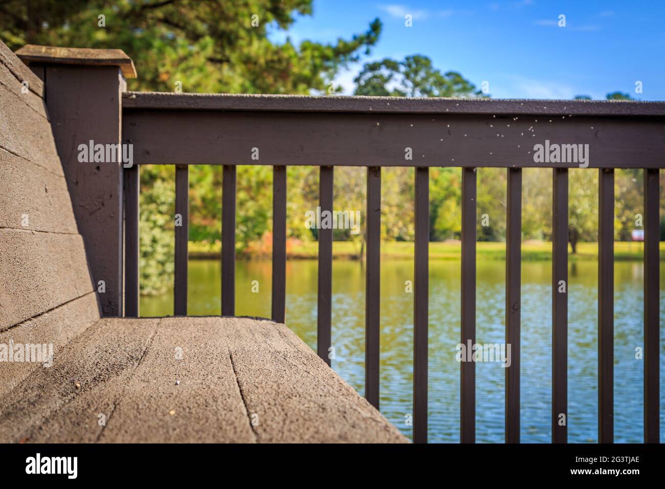 Wooden bench on levy overlooking a lake Stock Photo - Alamy