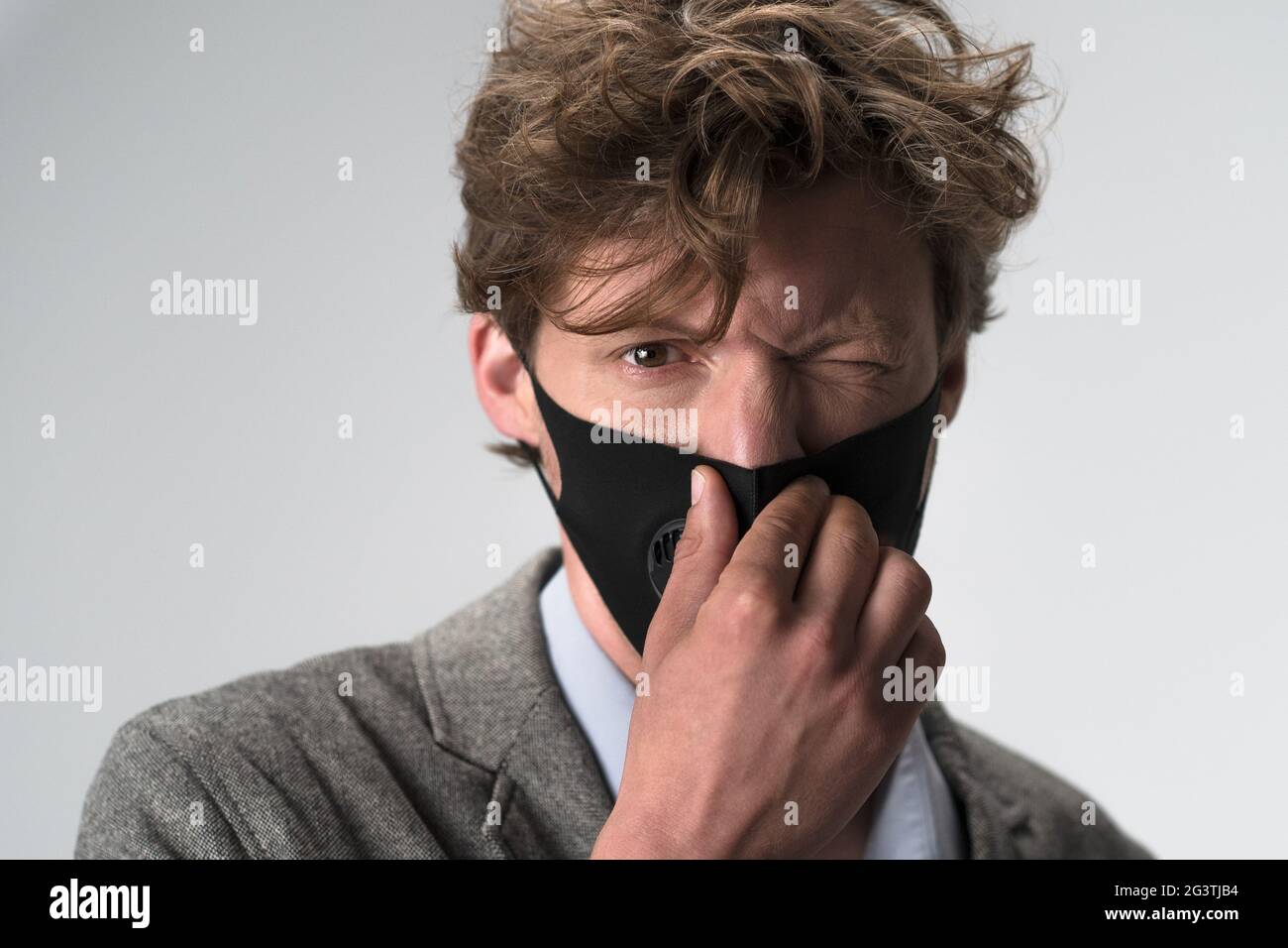 Messy hair handsome young man in grey jacket and a modern reusable ...