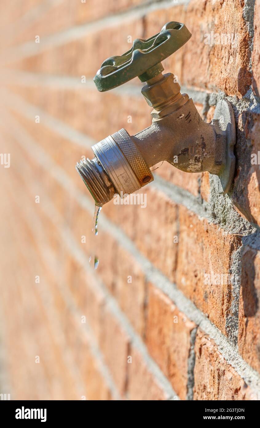 Leaky Spigot on Brick House Facade Stock Photo - Alamy