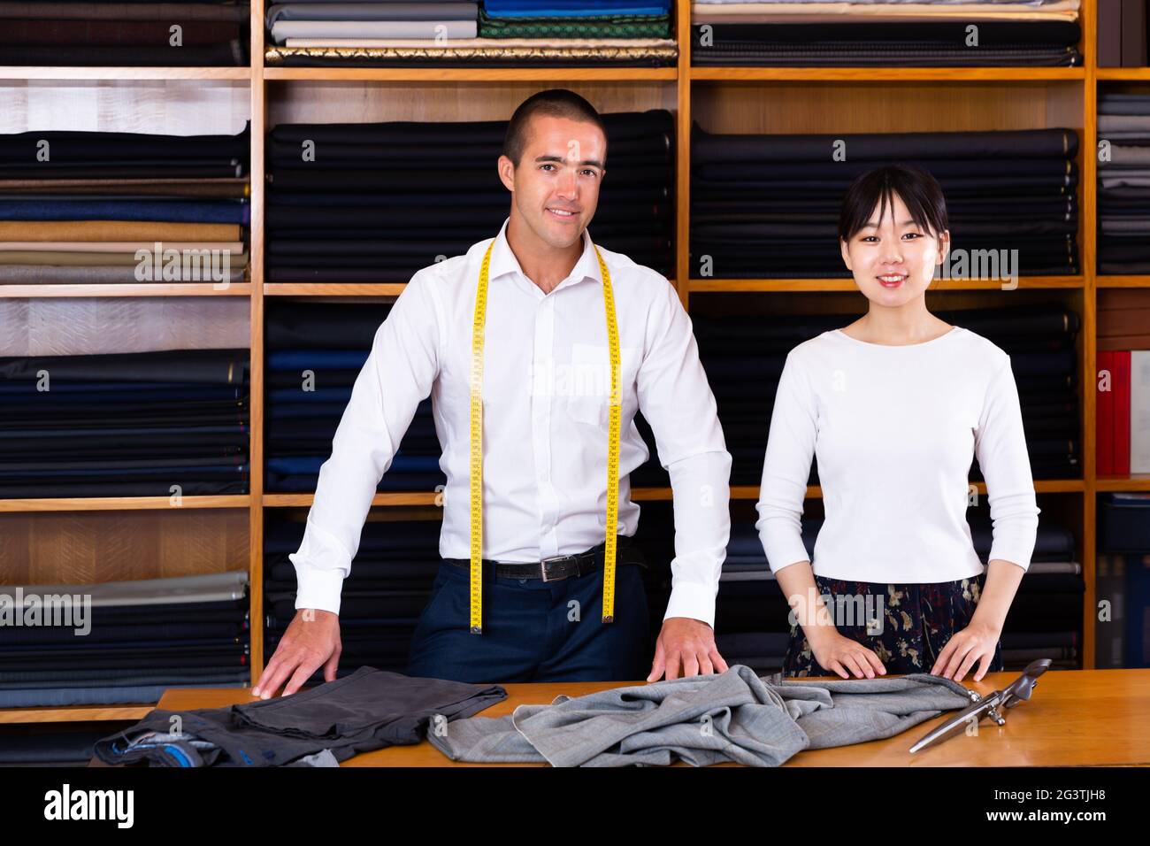 Successful man standing with Chinese salesgirl Stock Photo - Alamy