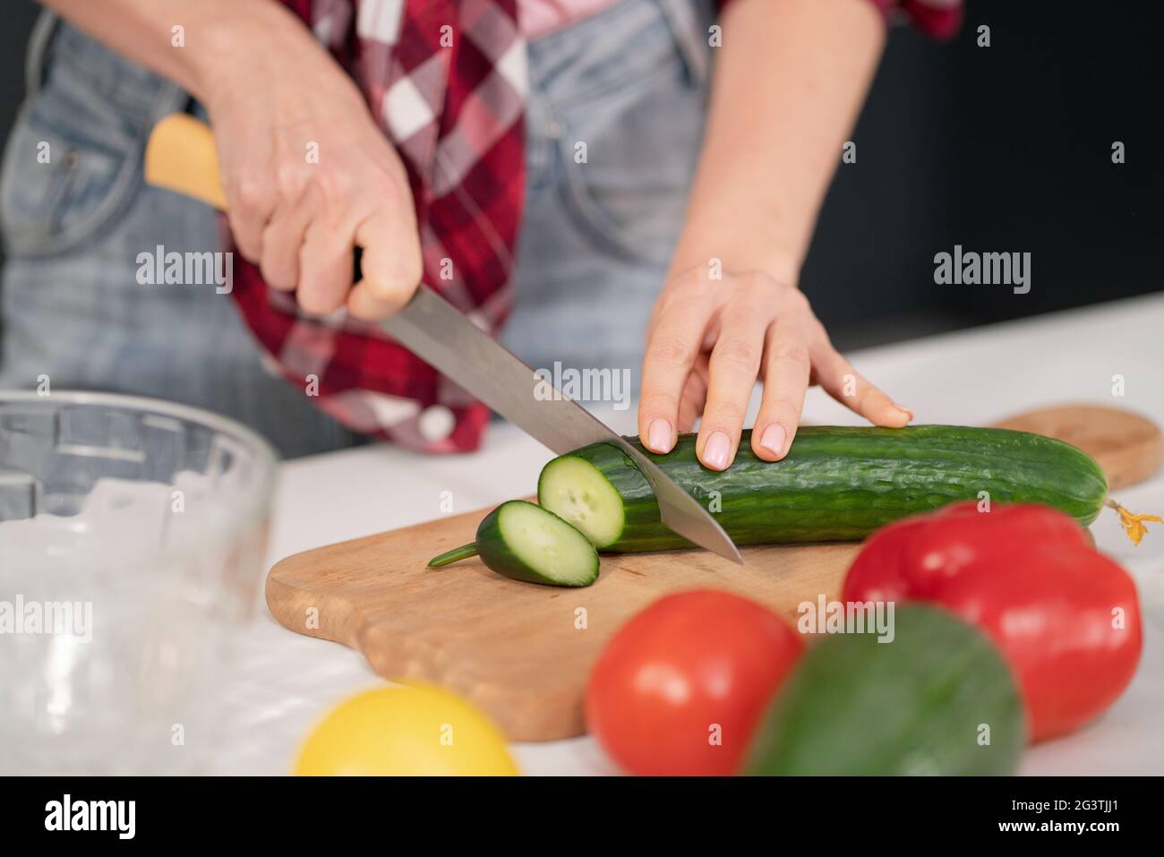 Close up. Young woman cutting ingredients on table cooking a lunch or ...