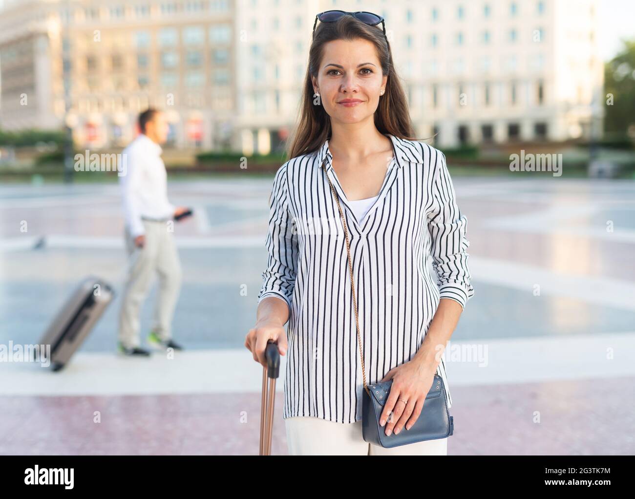 Young woman walking with baggage through city Stock Photo - Alamy
