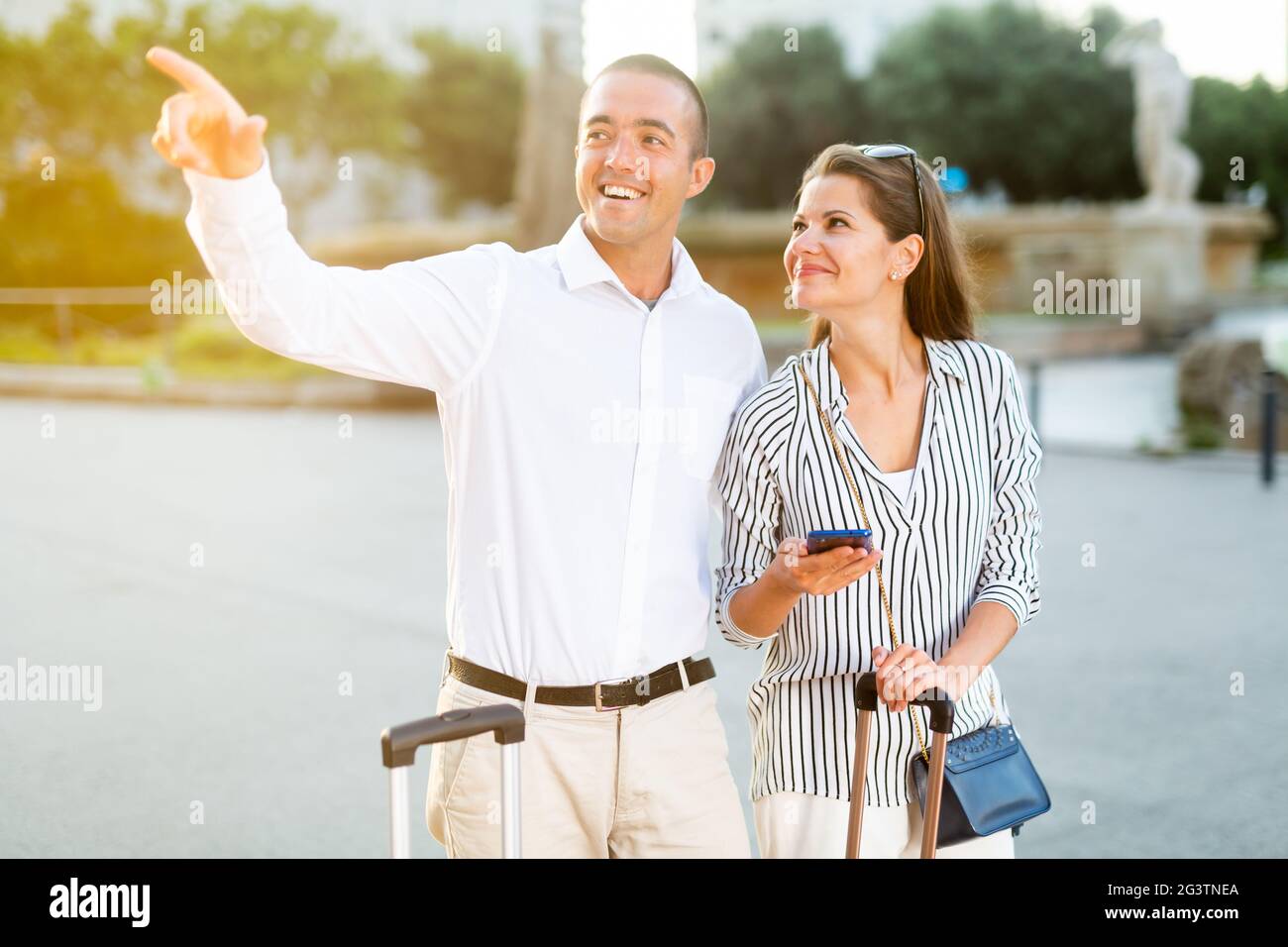 Tourist couple pointing at sights while walking around city Stock Photo ...
