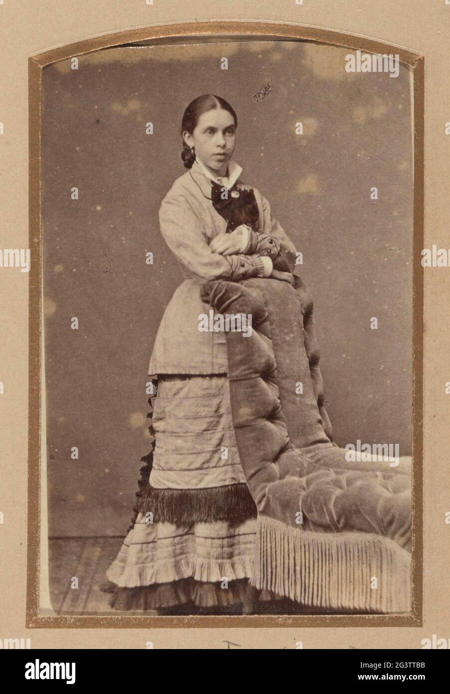 Portrait of a woman standing at an armchair. Part of album with 28 ...