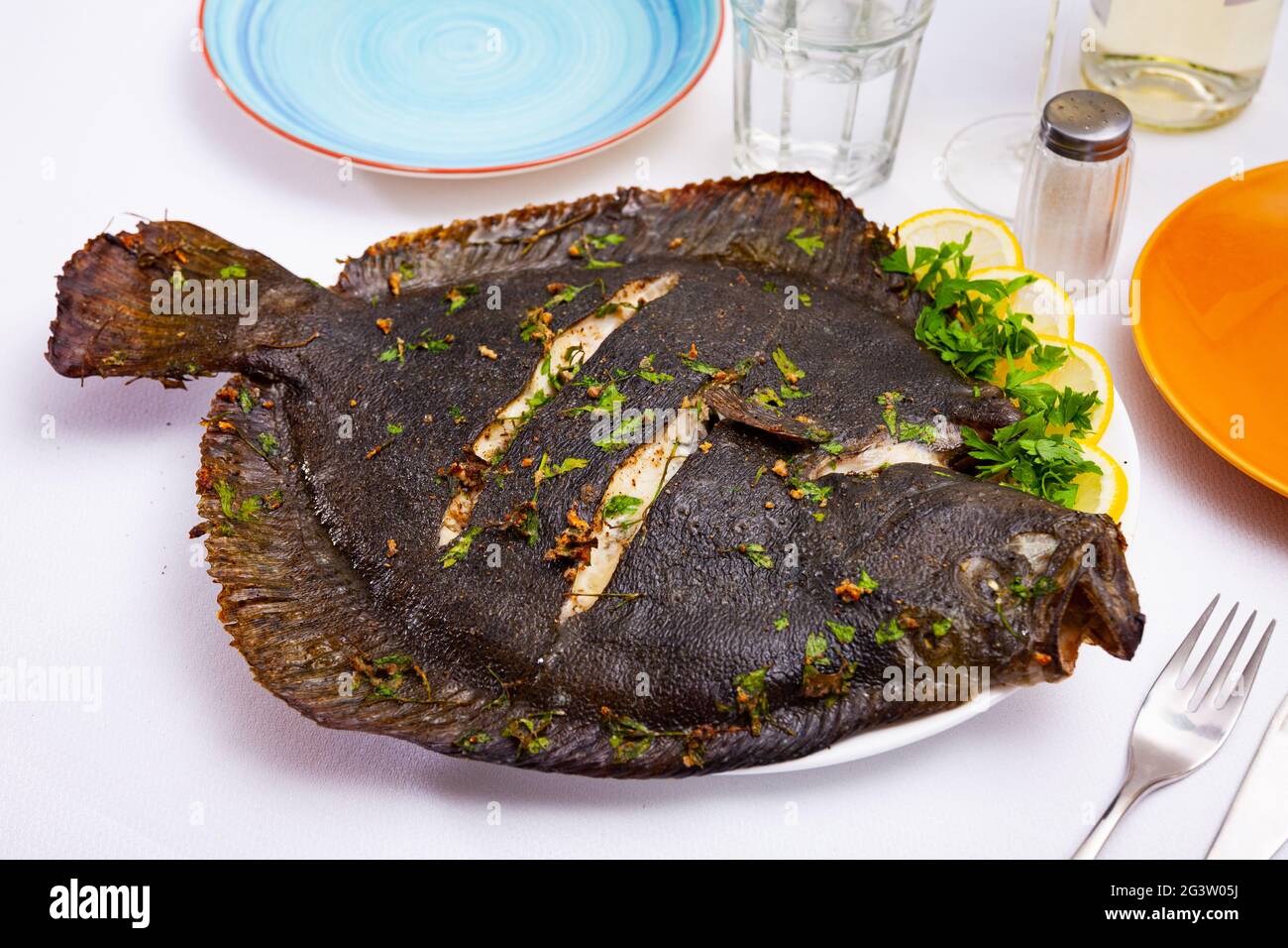Baked brill fish with lemon and greens Stock Photo - Alamy