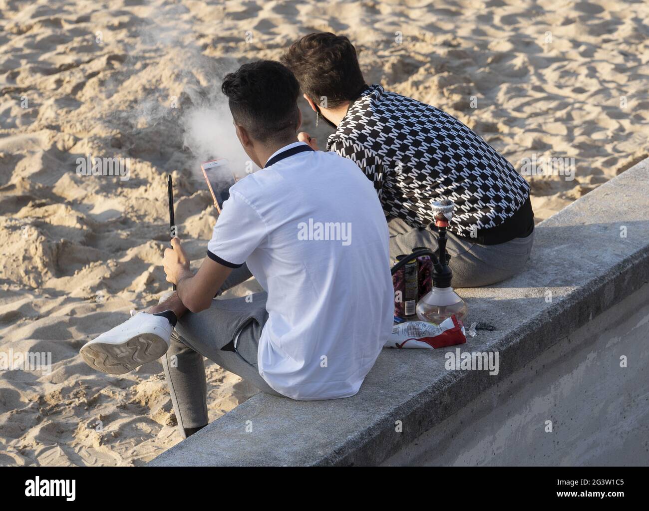 Closeup shot of two guys smoking hookah on the beach Stock Photo - Alamy