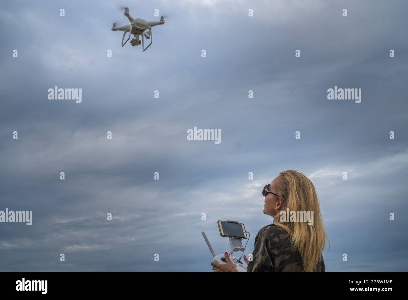 Happy woman taking photos with drone camera Stock Photo - Alamy