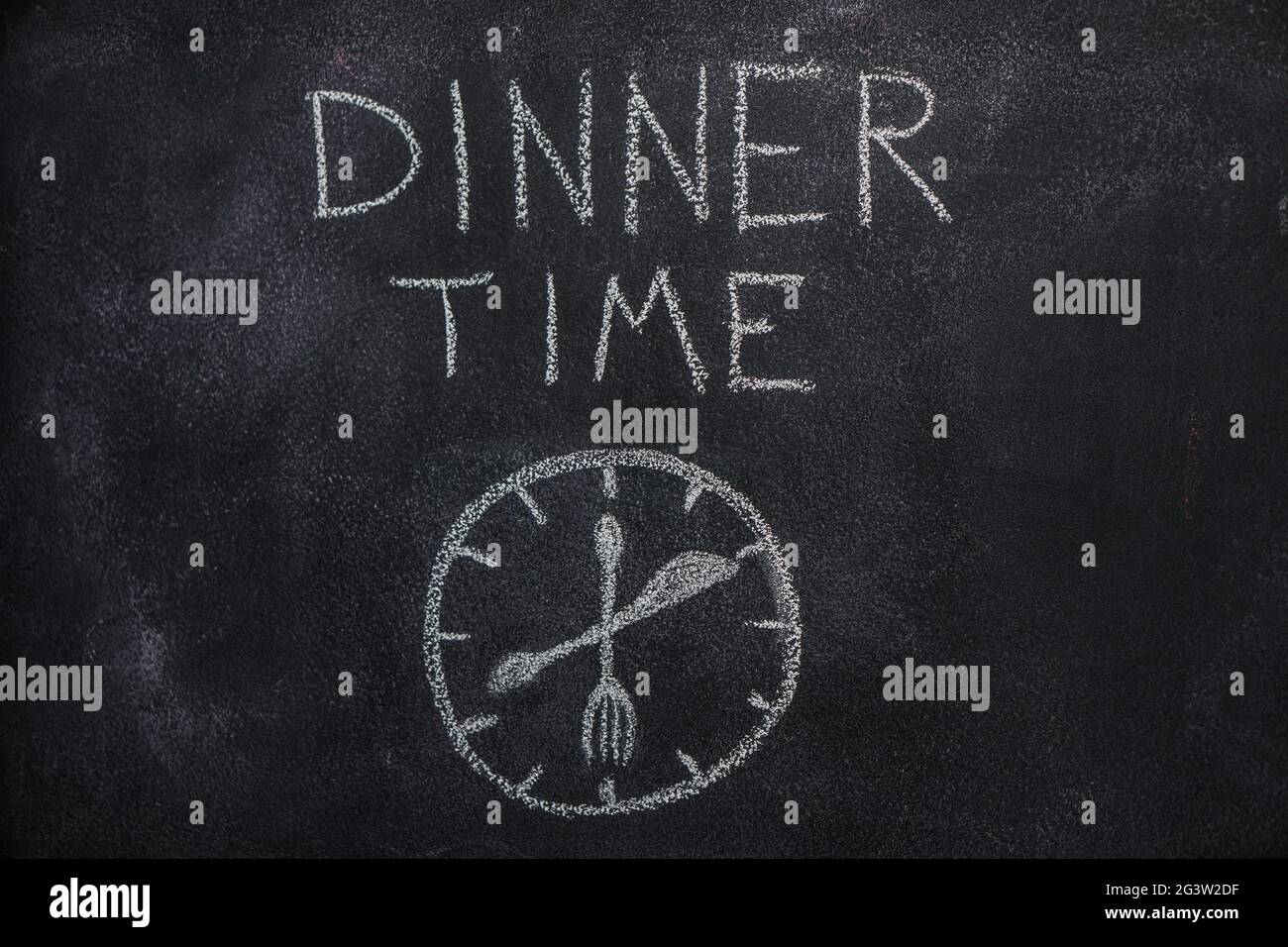 Dinner time text with clock on black chalkboard Stock Photo - Alamy