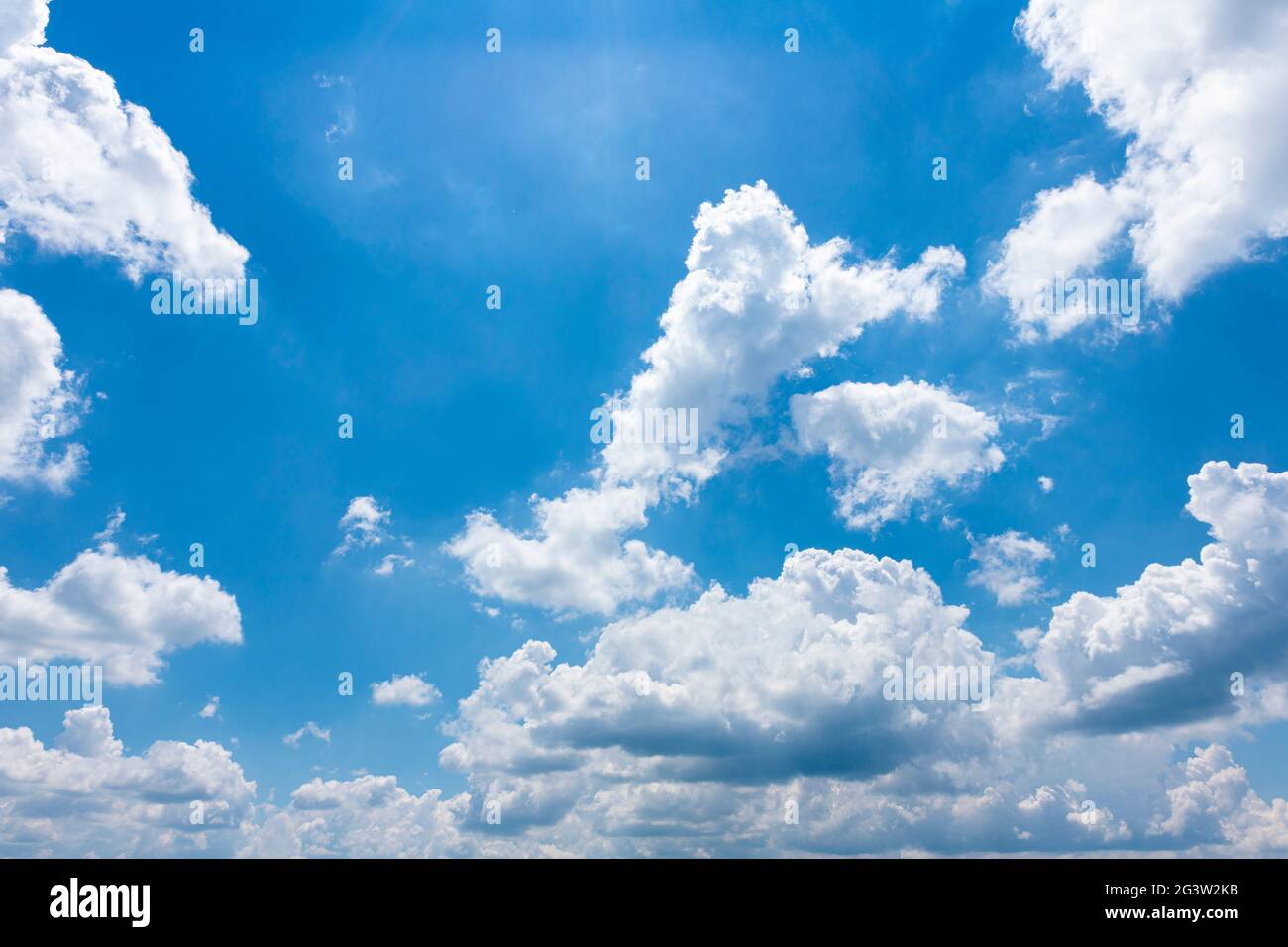 White fluffy clouds in the bright blue sky Stock Photo - Alamy