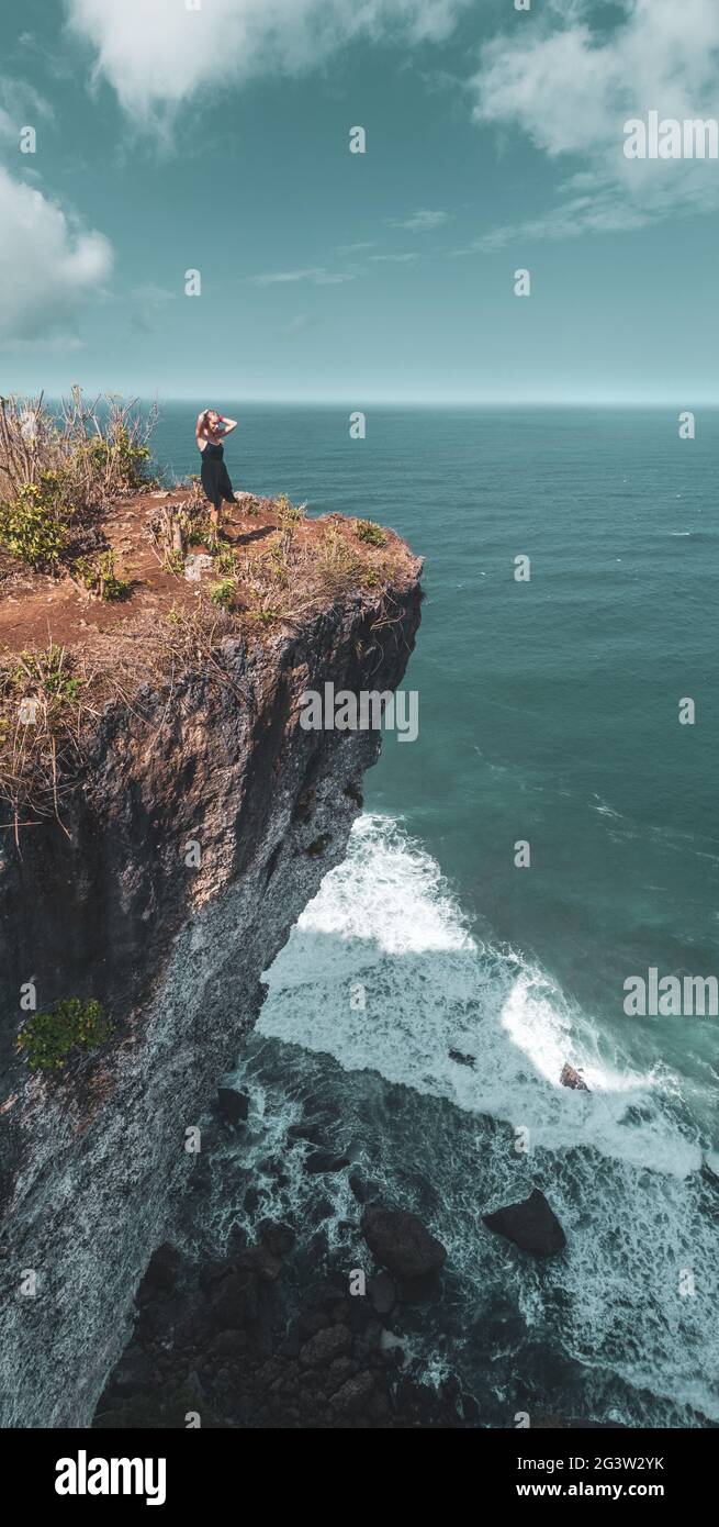 Aerial view of girl standing on the beautiful cliff Stock Photo - Alamy