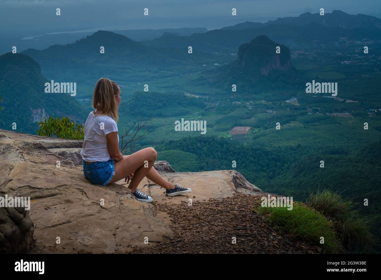 Girl sitting on edge cliff hi-res stock photography and images - Alamy