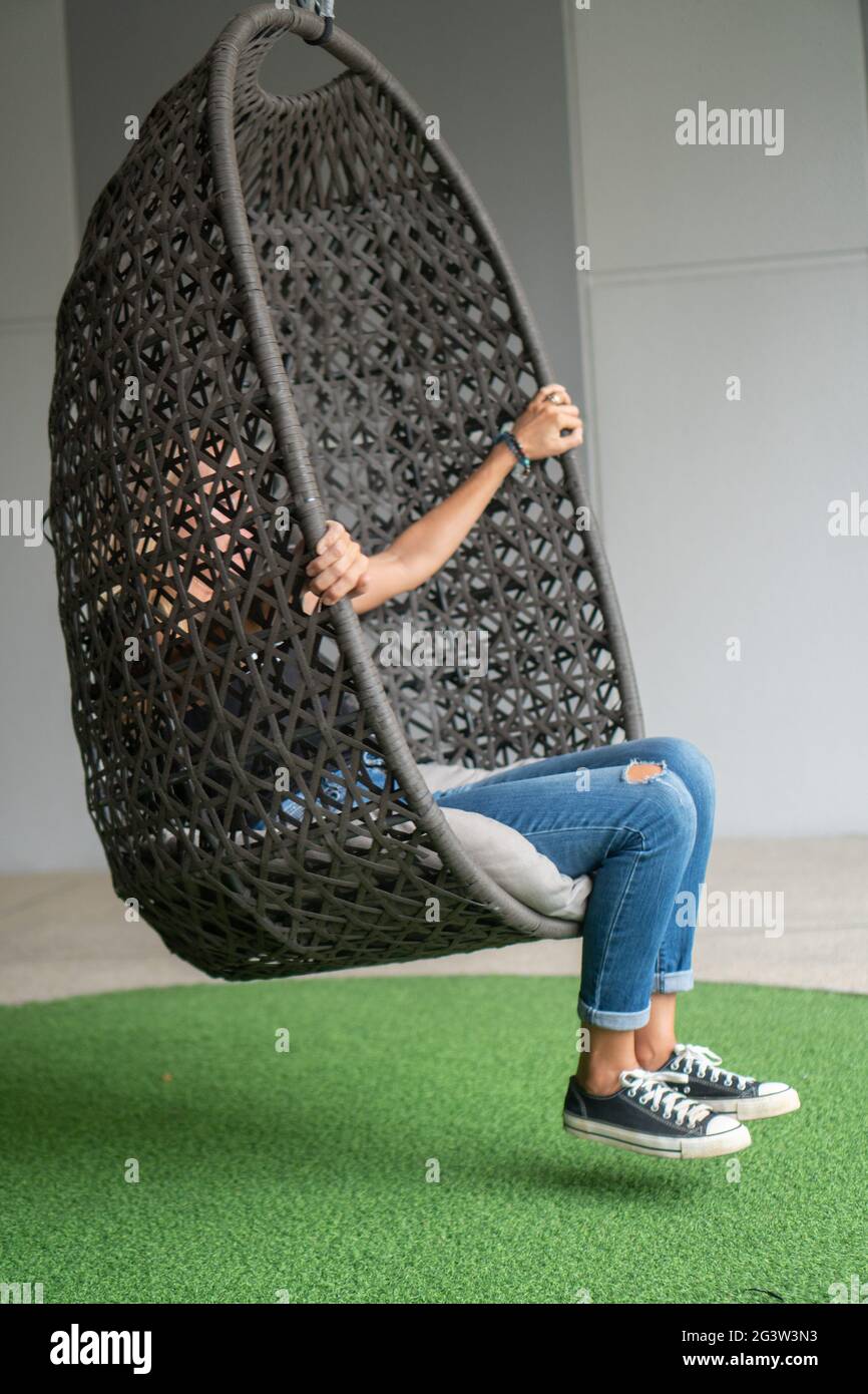 Woman in nest chair Stock Photo - Alamy