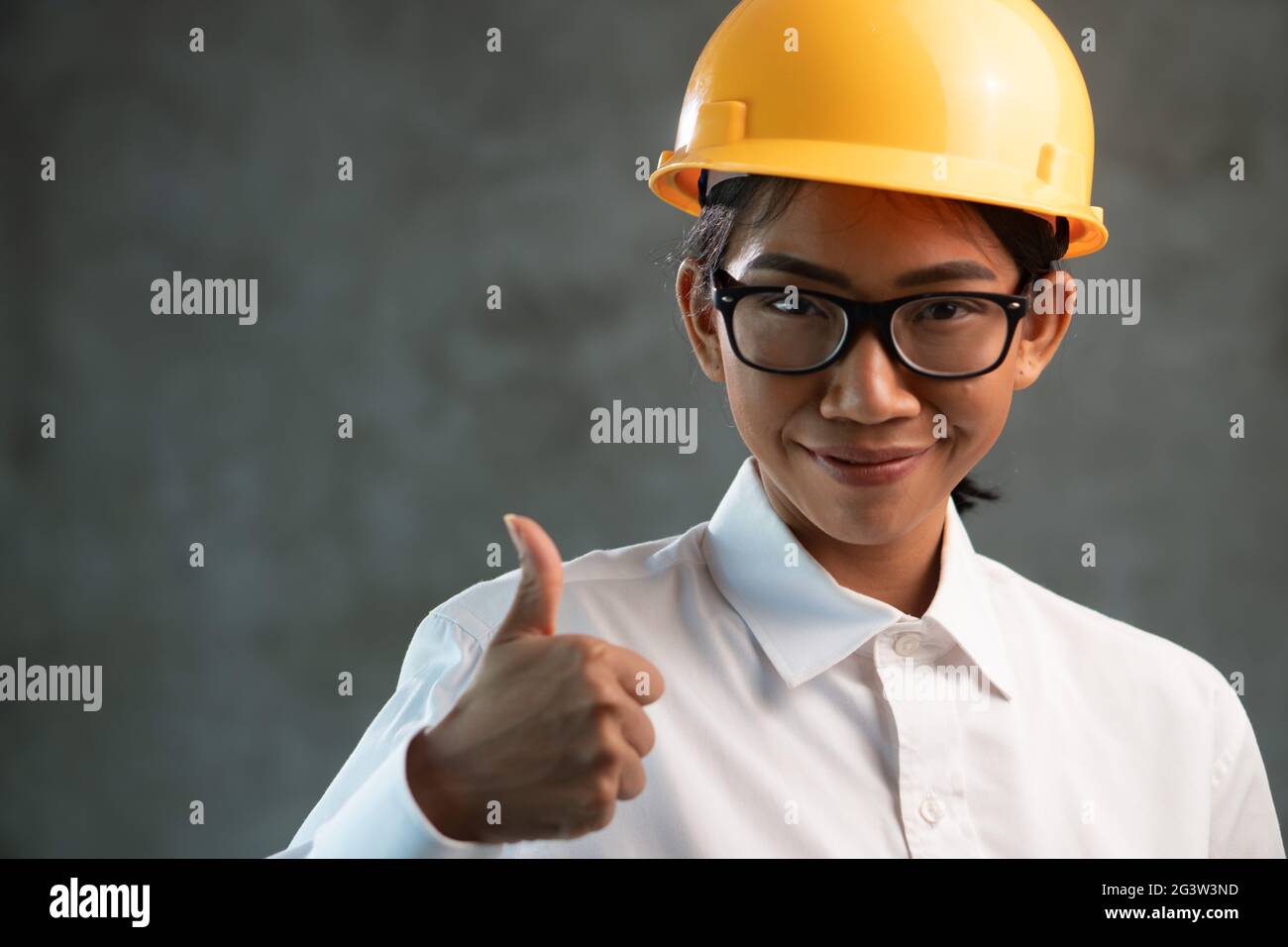 Portrait of smiling Asian woman engineer showing thumbs up gesture ...