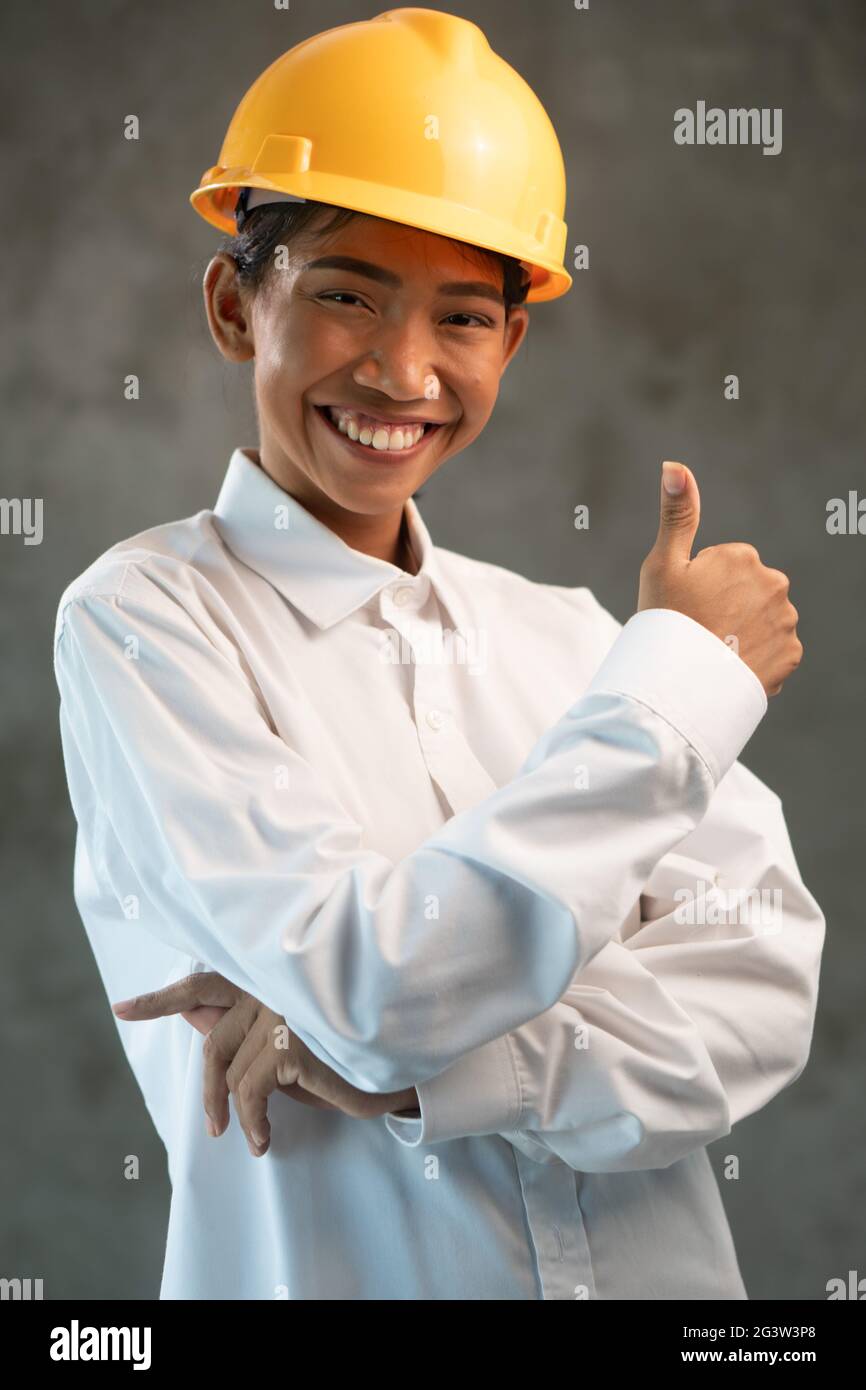 Portrait of smiling Asian woman engineer showing thumbs up gesture ...