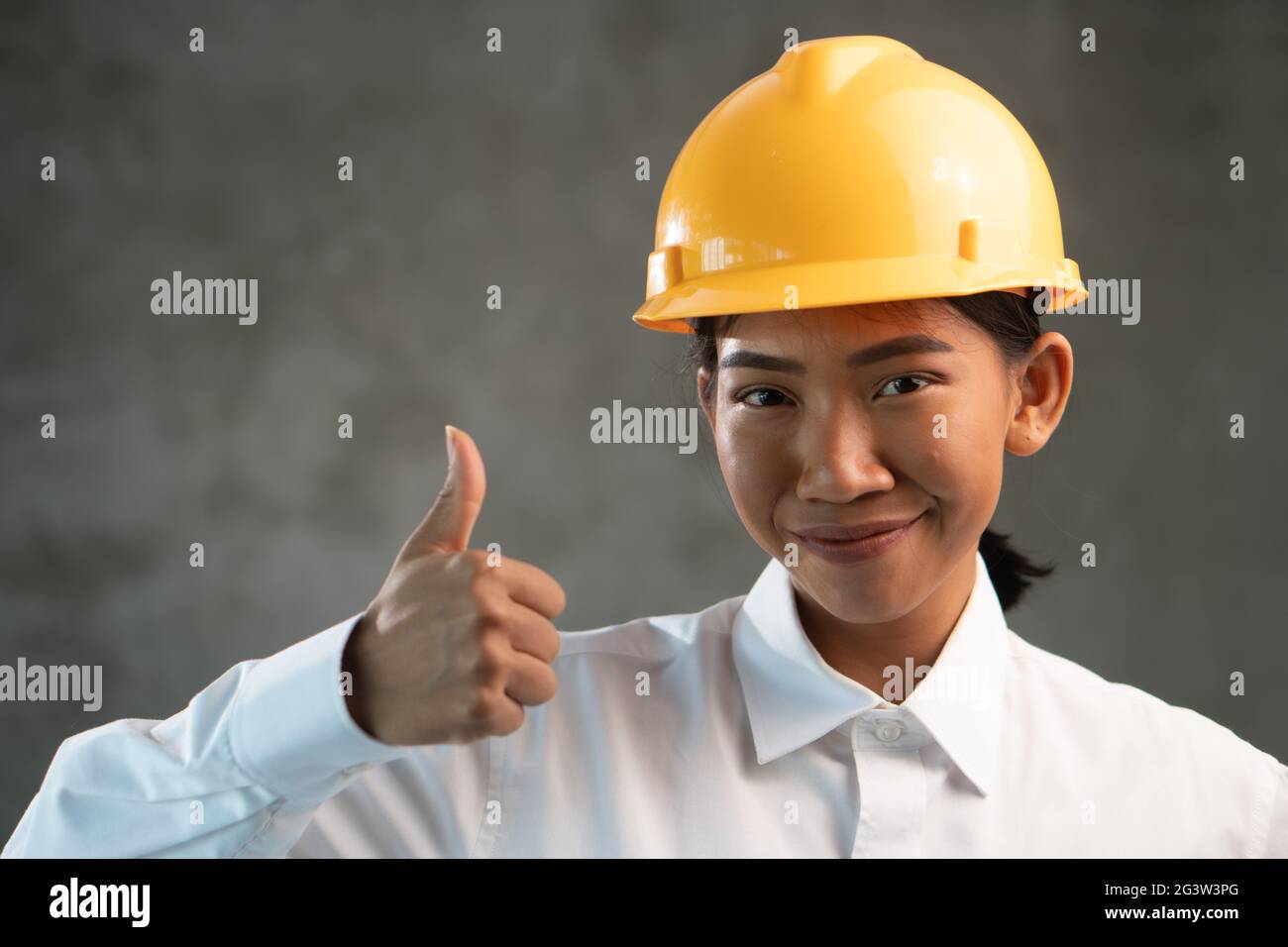 Portrait of smiling Asian woman engineer showing thumbs up gesture ...