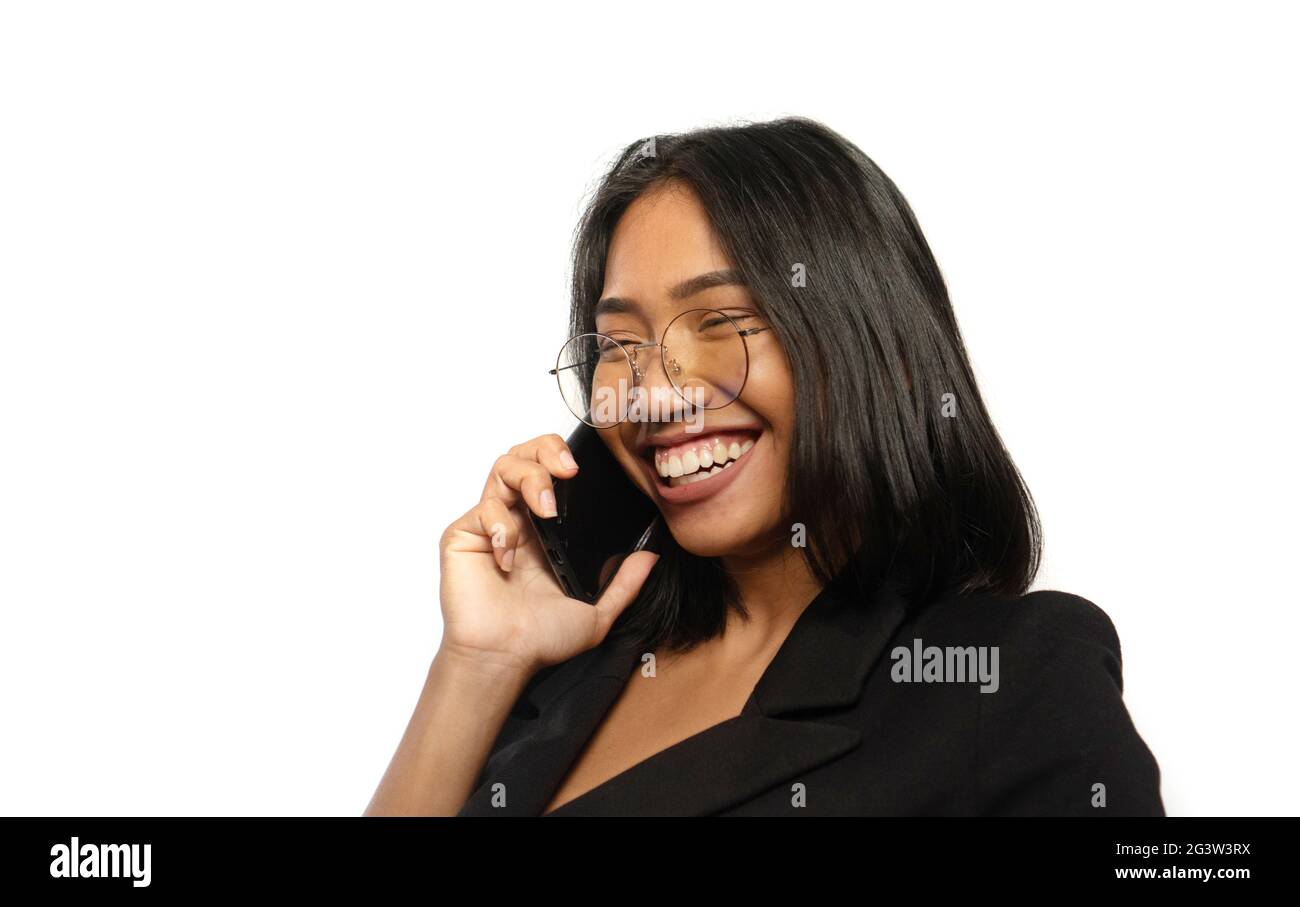 Attractive young Asian business woman smiling while talking on mobile ...