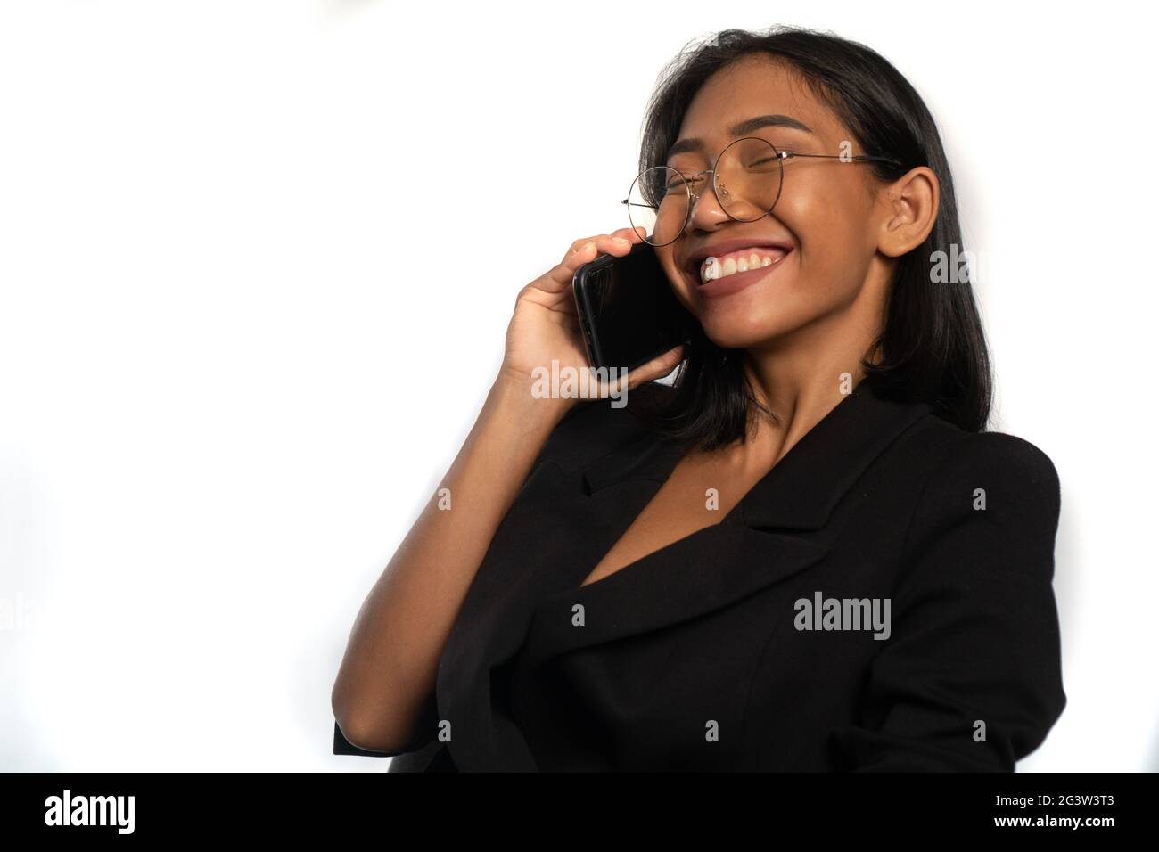 Attractive young Asian business woman smiling while talking on mobile ...