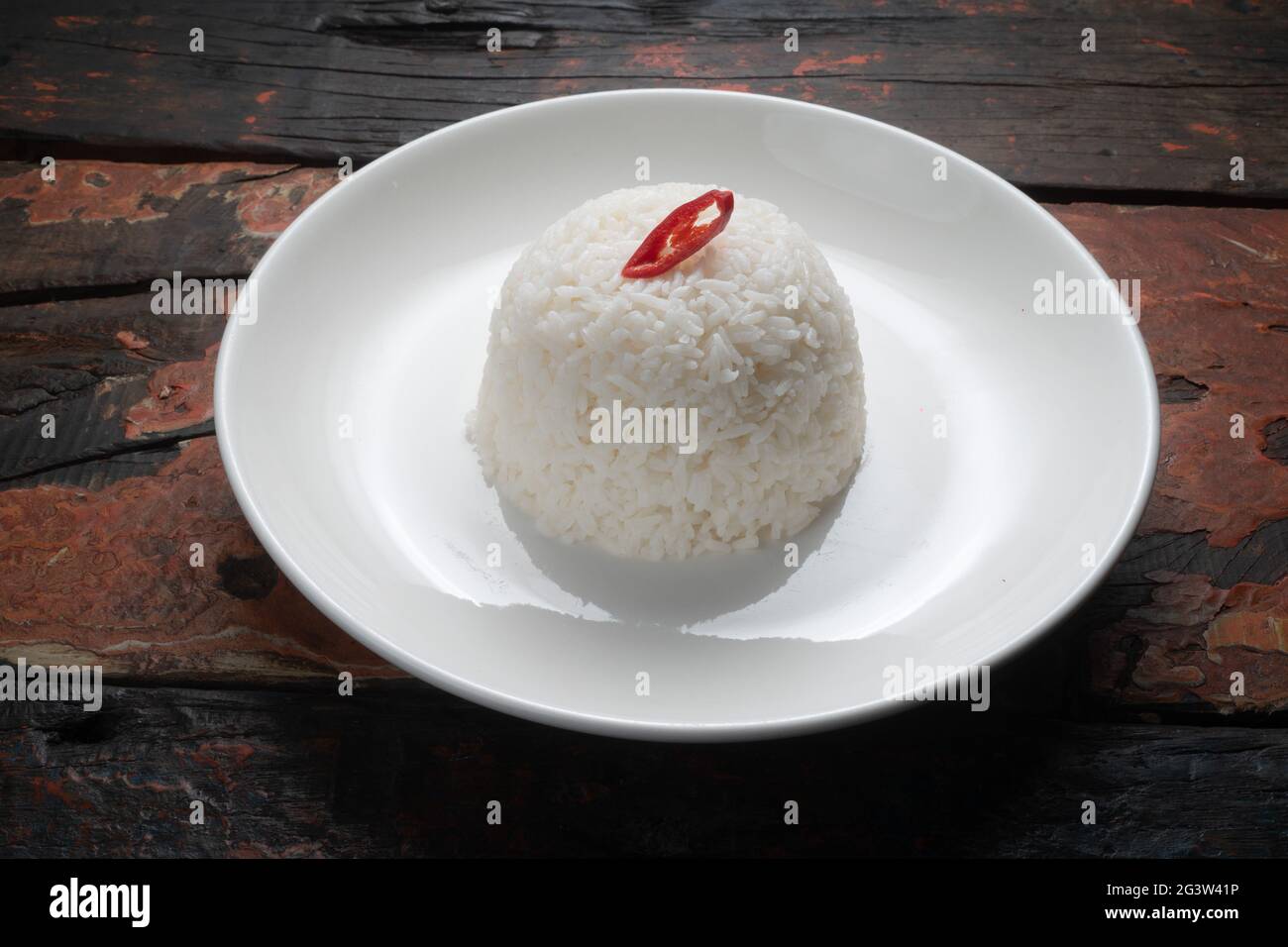 Jasmine steamed rice on the white plate on rustic wooden kitchen table ...