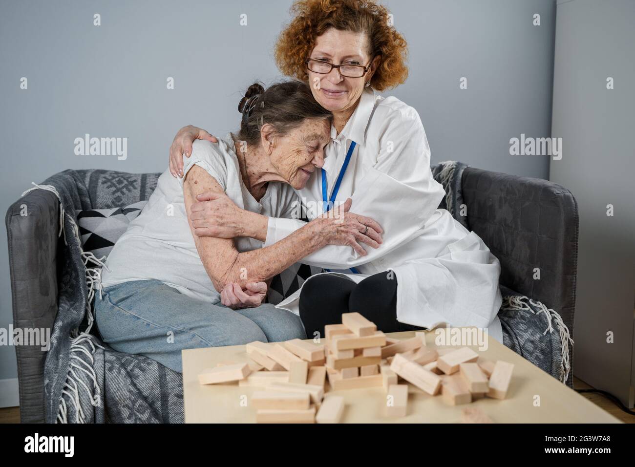 Senior woman practice skills, build wooden blocks, build tower and try ...