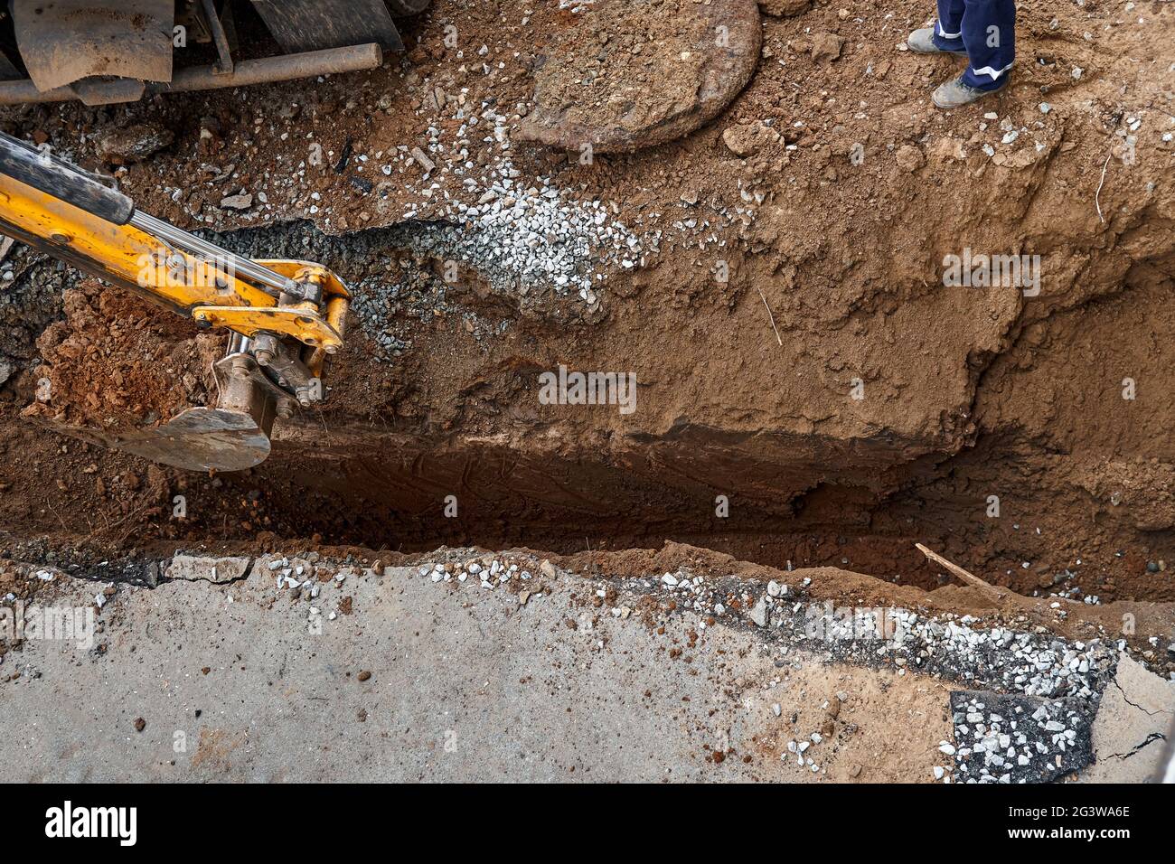 Bucket of modern yellow excavator digs deep pit to change old and lay ...