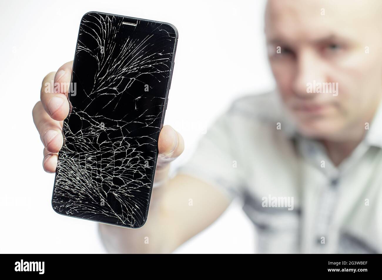 Phone With A broken screen close-up. A white man is holding a black ...