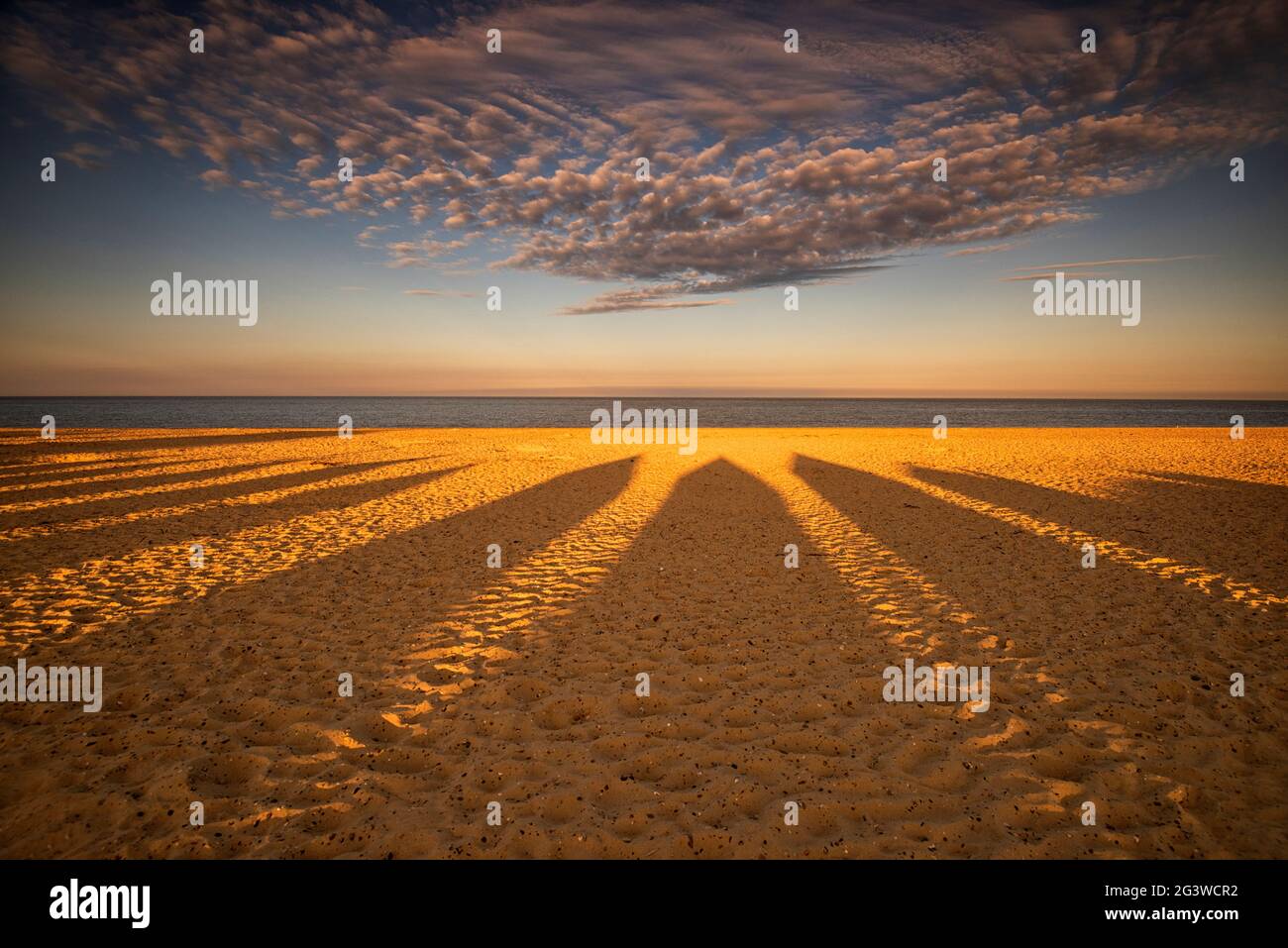 Sunset shadows of Beach Huts on the beach at Southwold in Suffolk ...
