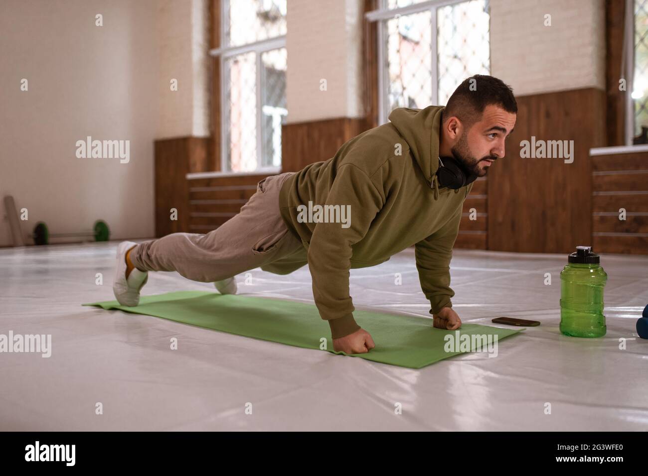 Muscular sportsman doing exercises alone in gym. Young handsome sports ...