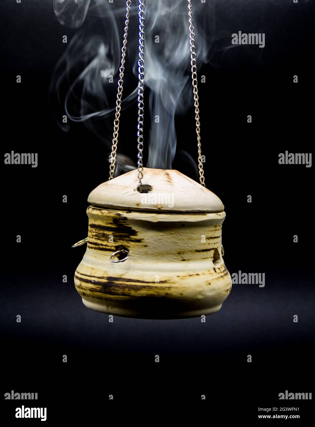 Bowl of incense hanging smoke on black background Stock Photo - Alamy