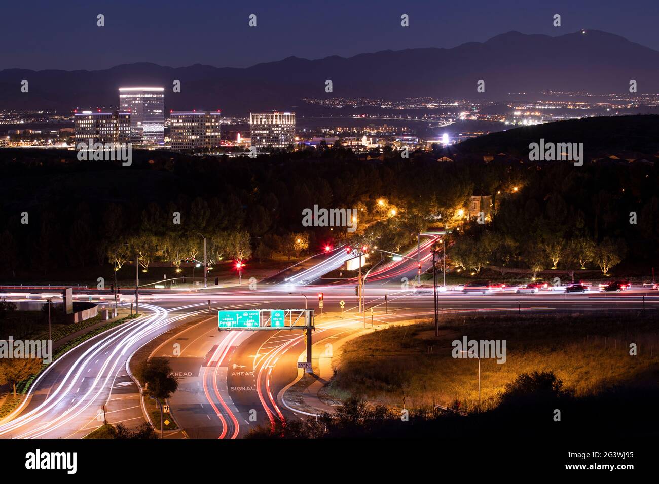 Twilight evening view of traffic streaming by the downtown skyline of ...
