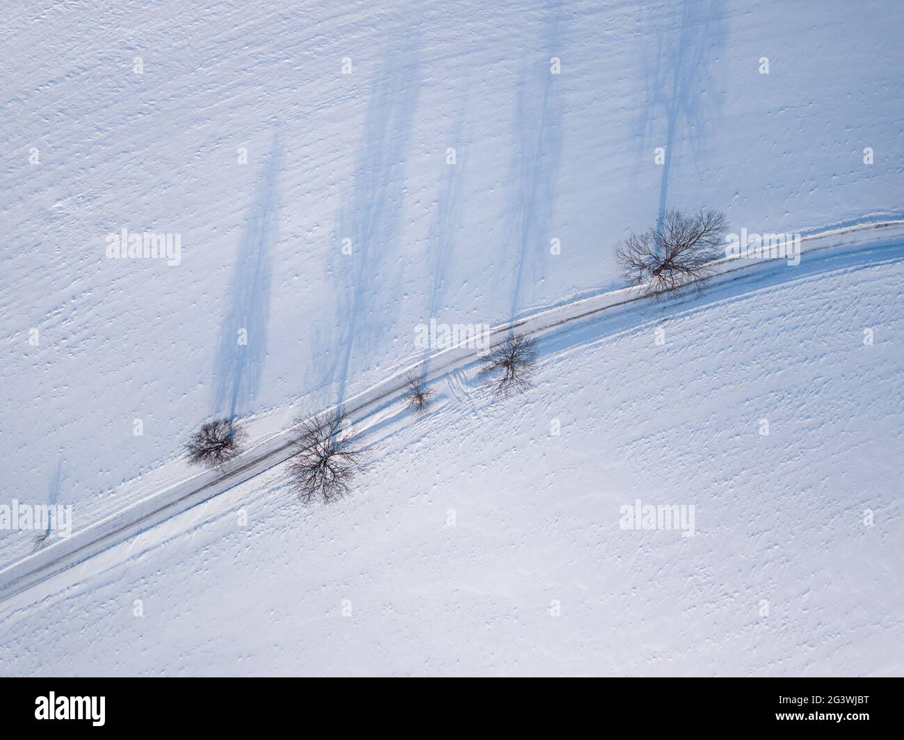 Windy winter road in snow covered fields Stock Photo - Alamy