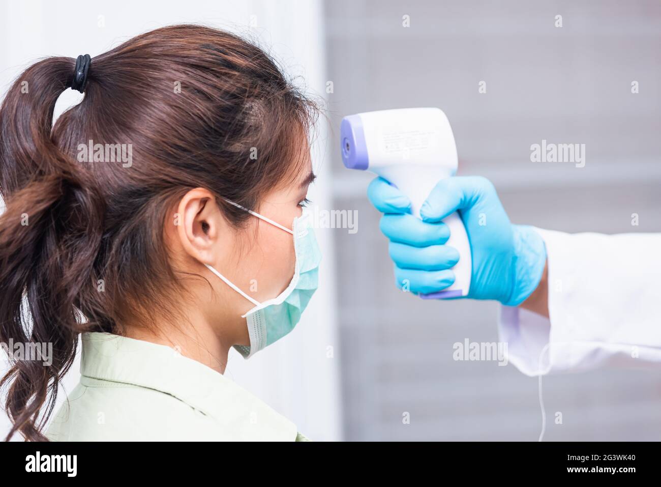 Doctor man use infrared forehead thermometer gun checking measuring ...