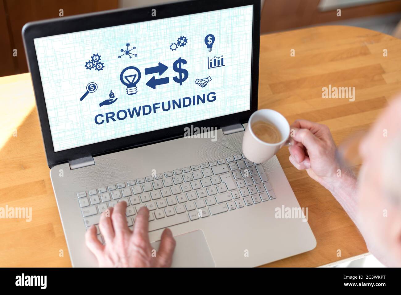 Man using a laptop with crowdfunding concept on the screen Stock Photo ...