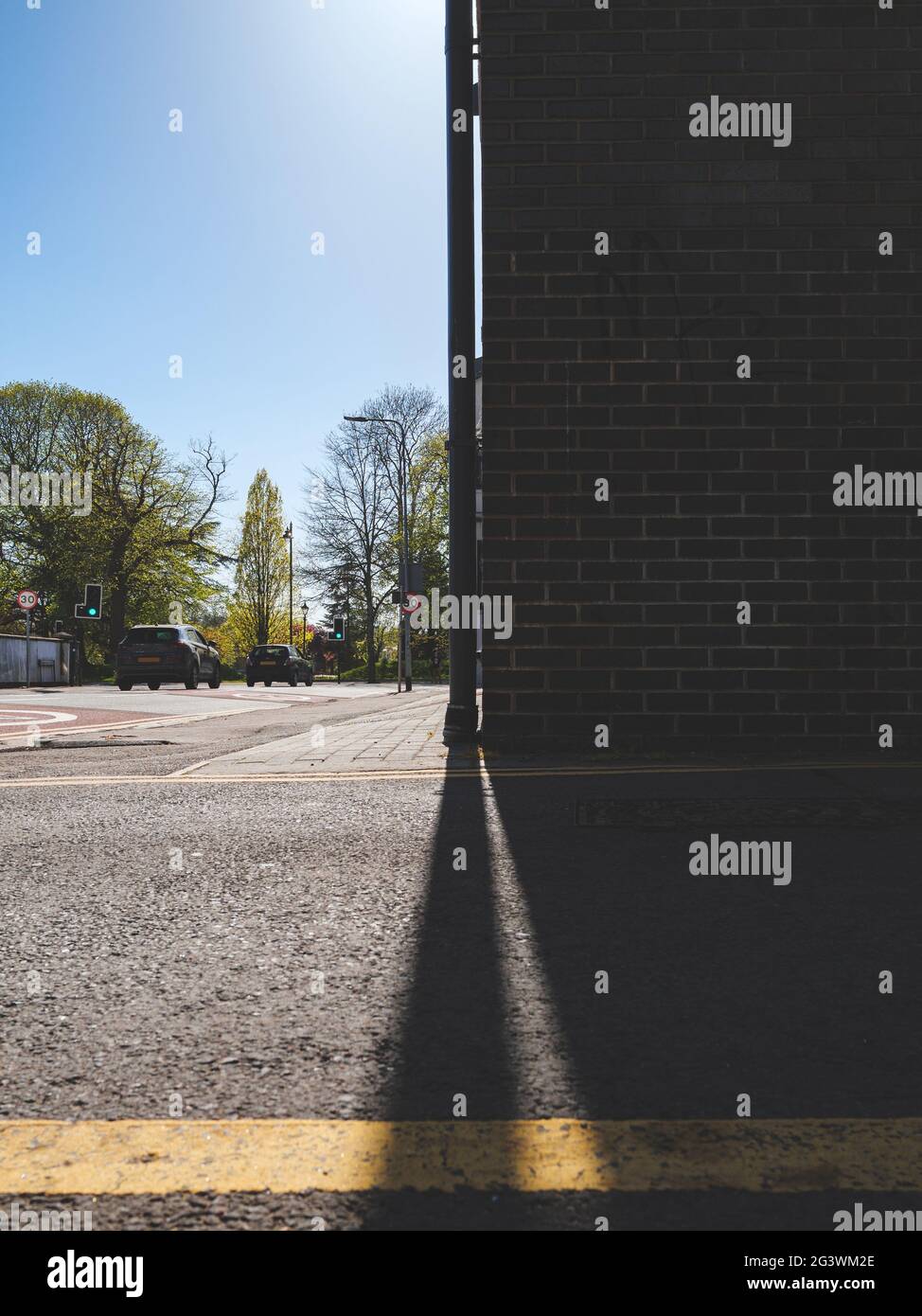 A building with outdoor rain gutter casting shadow on a clear sunny day ...