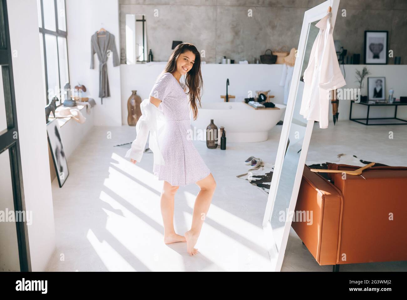 Beautiful girl trying dress in room Stock Photo - Alamy