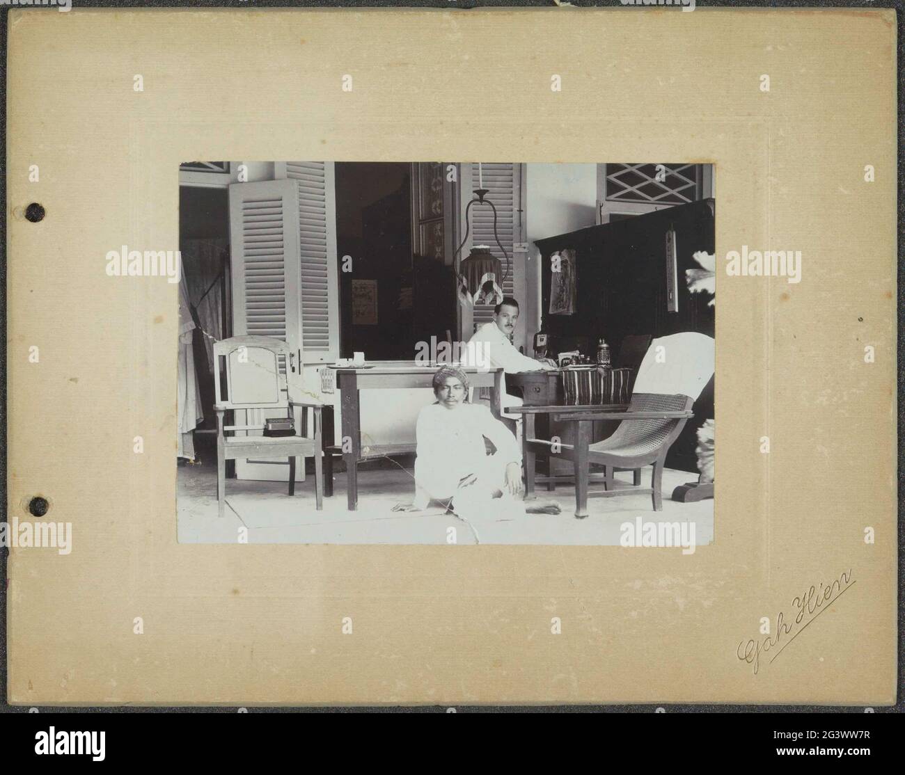 European and Indian men on a veranda in the Dutch East Indies. Part of ...
