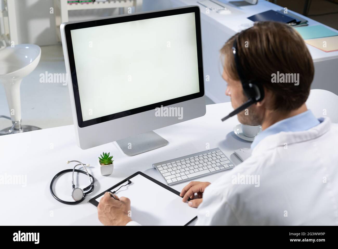 Caucasian male doctor making consultation video call using computer and ...