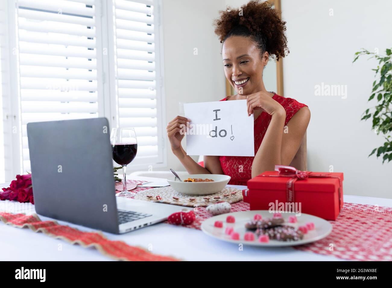 African american woman holding placard with i do text on videocall on ...