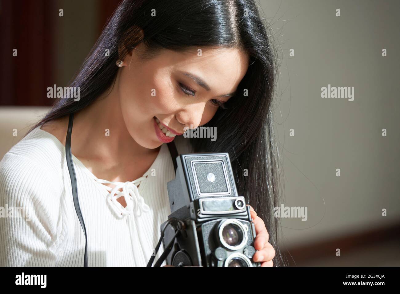 Satisfied attractive young Asian photographer with black hair looking ...