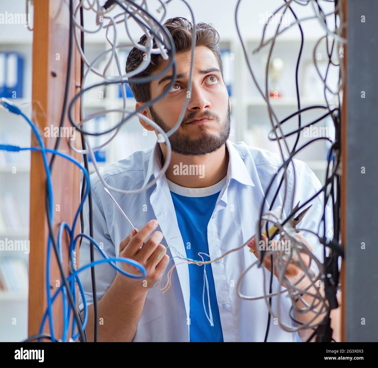 Electrician trying to untangle wires in repair concept Stock Photo - Alamy