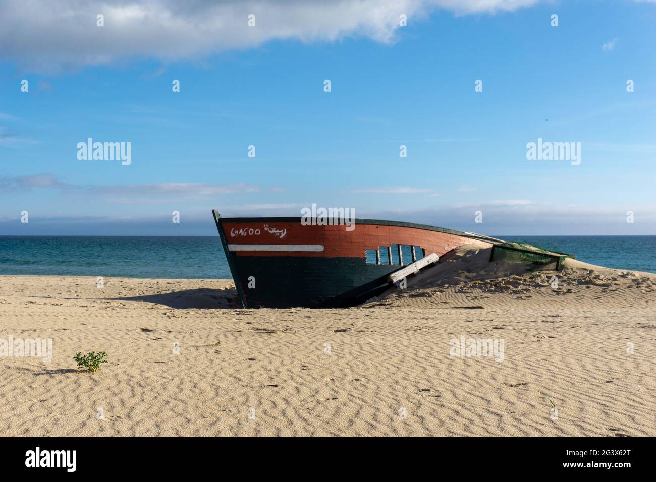 Colorful wreck of an old wooden rowboat buried in the sand Stock Photo ...