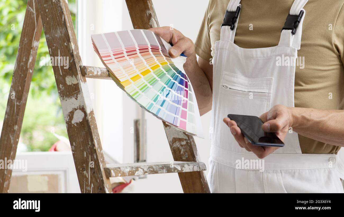 hands of house painter man decorator choose the color using the sample ...