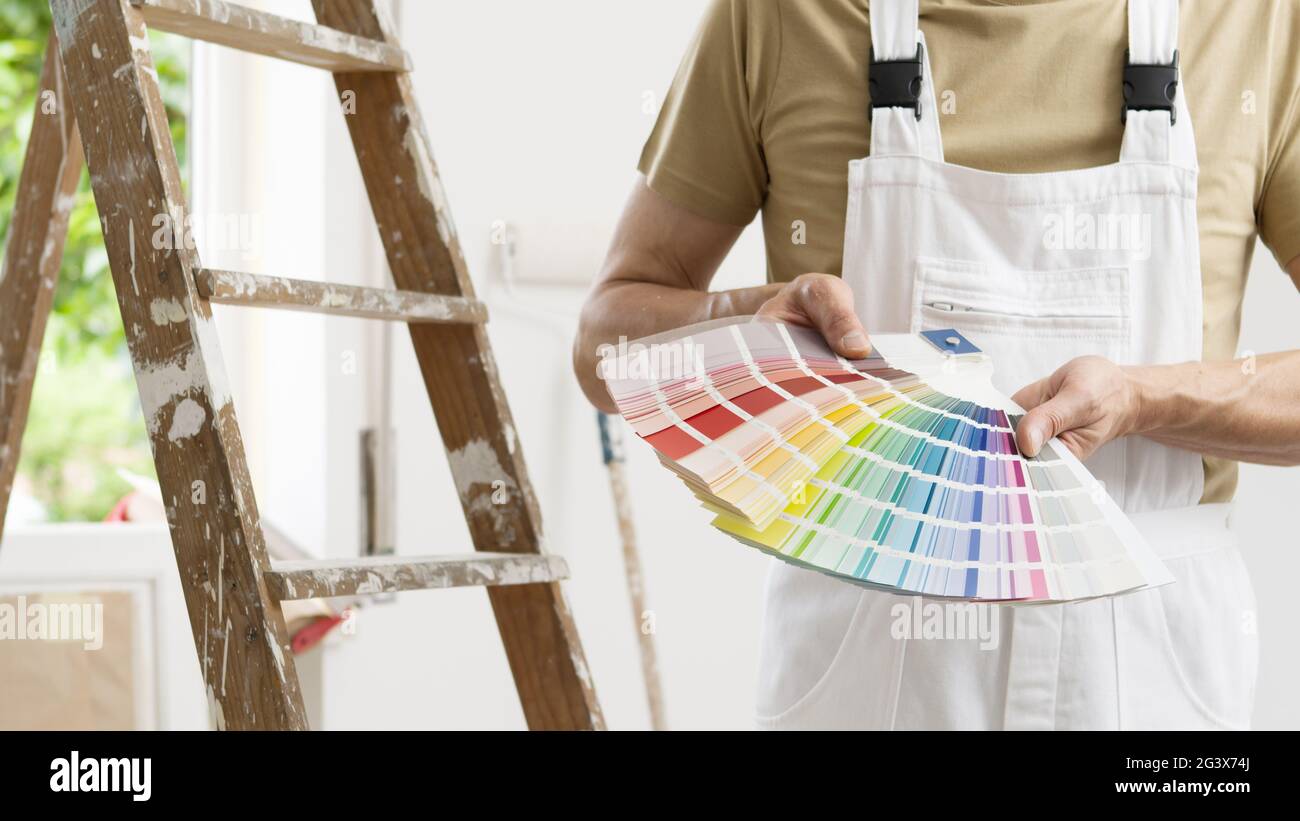 hands of house painter man decorator choose the color using the sample ...
