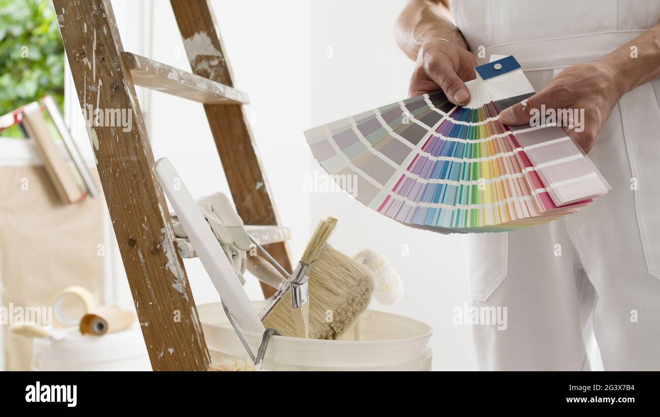 hands of house painter man decorator choose the color using the sample ...