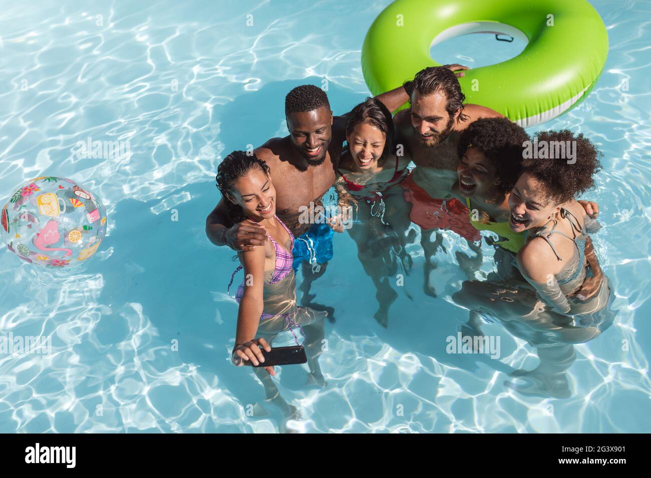 Diverse group of friends having fun and taking selfie in swimming pool ...