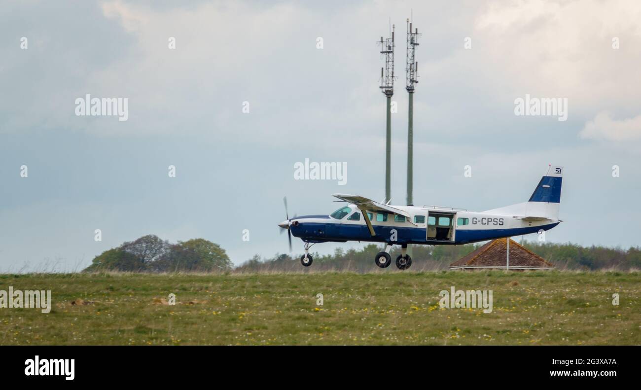 a Cessna Grand Caravan 208B light aircraft returns to land on a grass ...