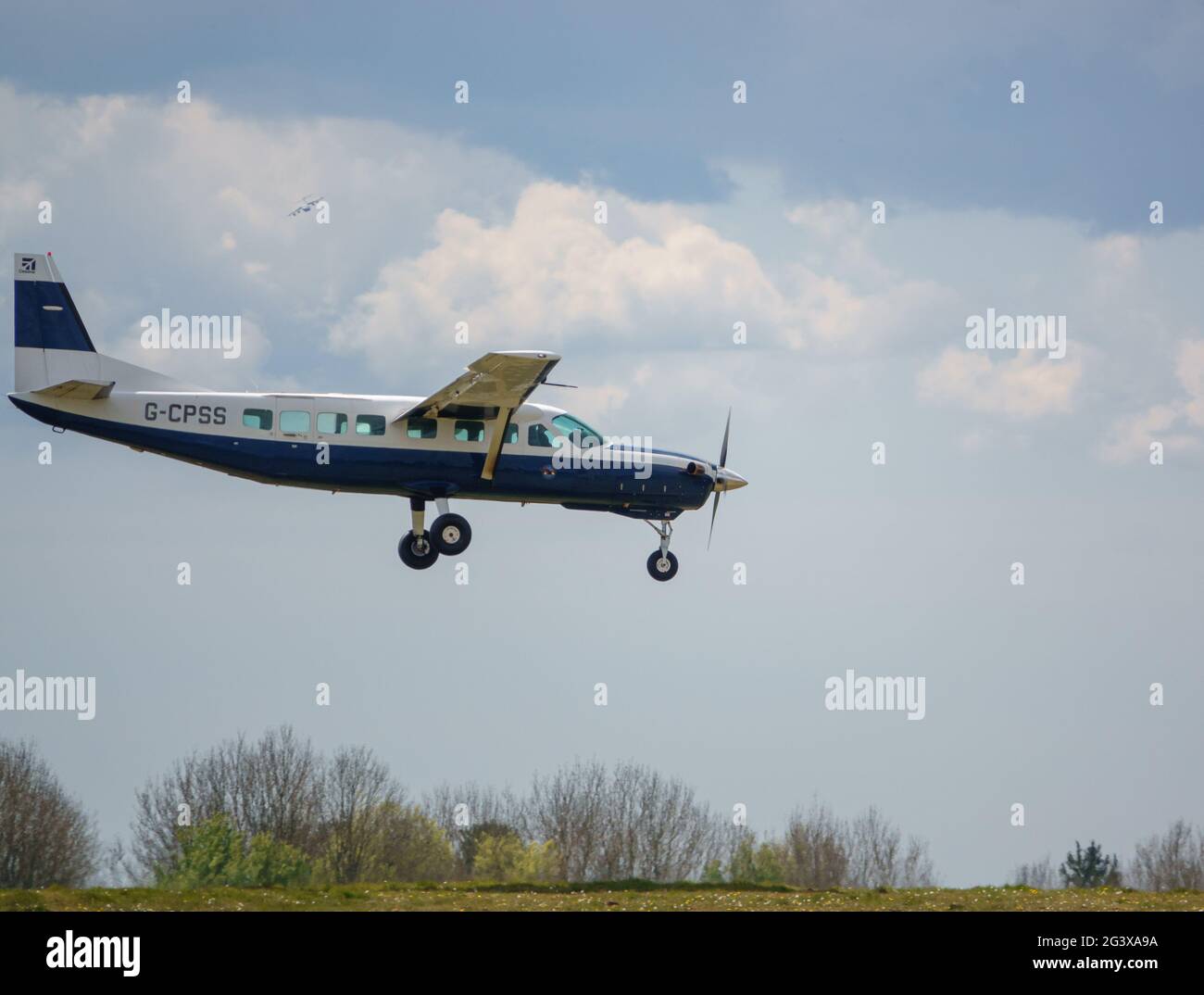 a Cessna Grand Caravan 208B light aircraft returns to land on a grass ...