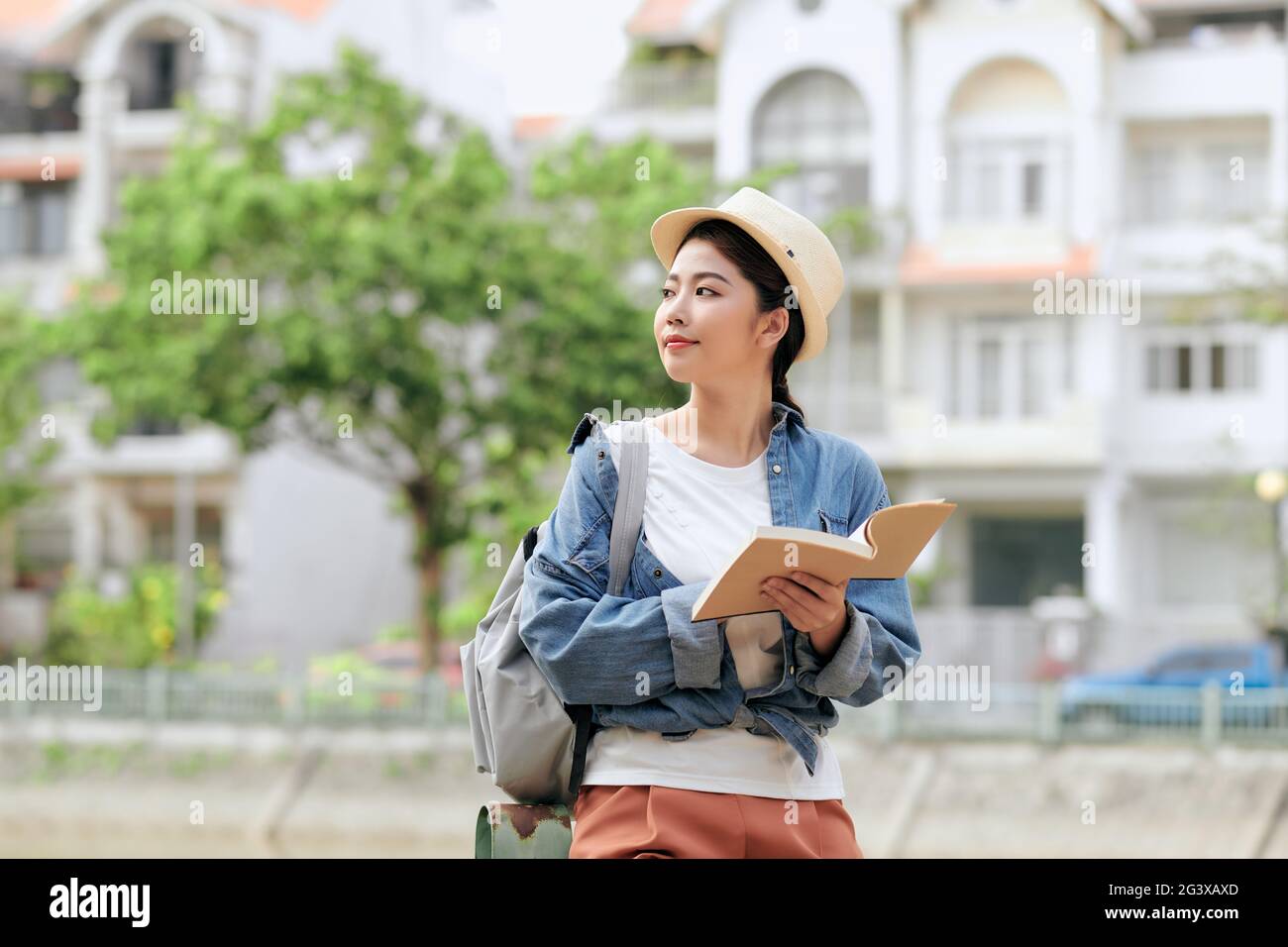 Tourist with travel guide book. Young woman traveler smiling happy ...